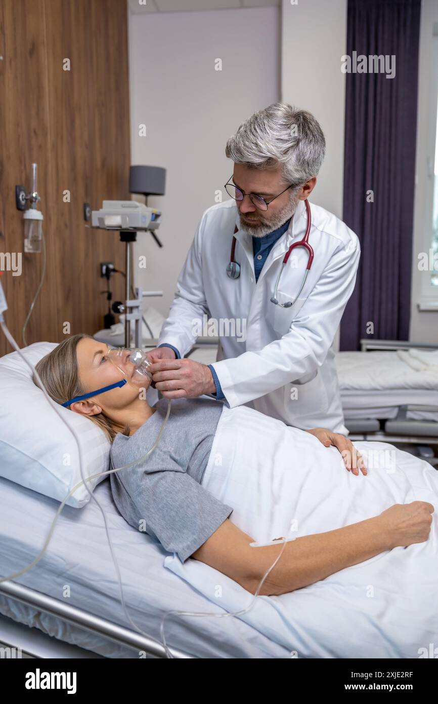 Doctor putting an oxygen mask on a female patient Stock Photo - Alamy