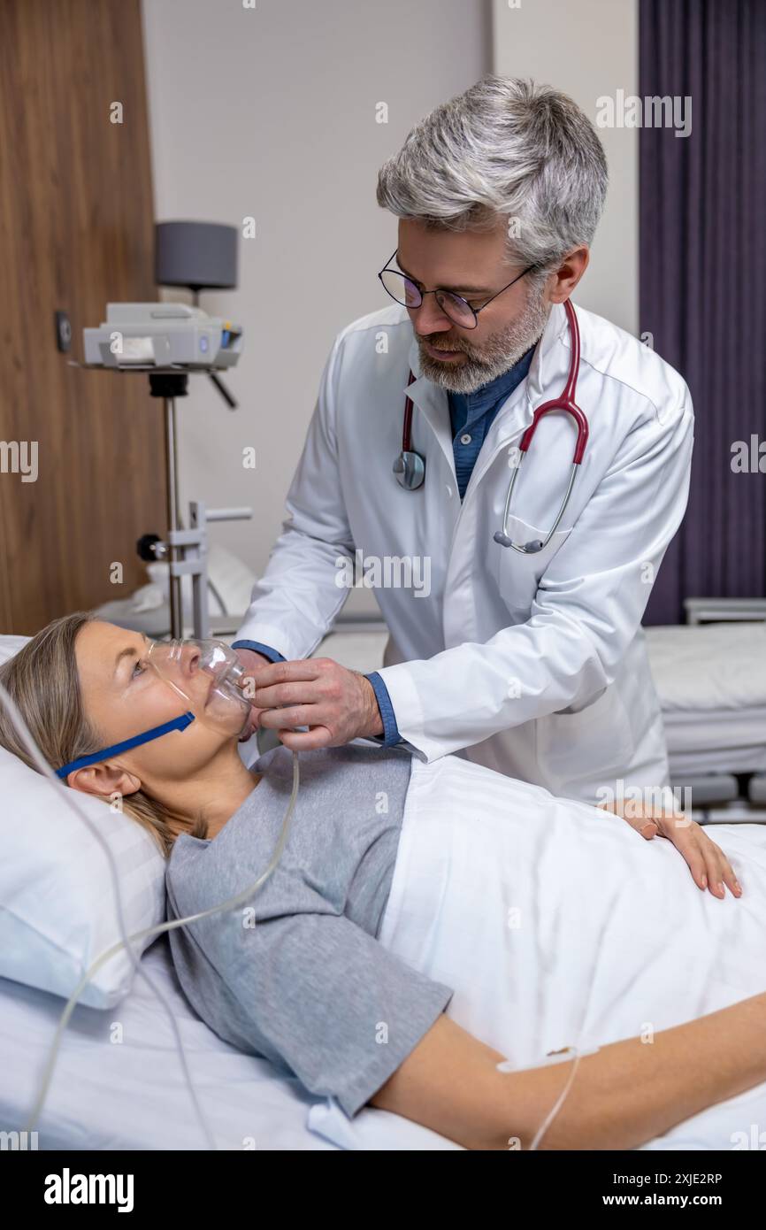Doctor putting an oxygen mask on a female patient Stock Photo - Alamy