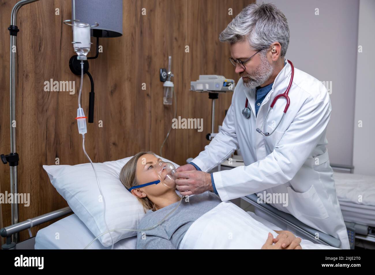 Doctor putting an oxygen mask on a female patient Stock Photo - Alamy