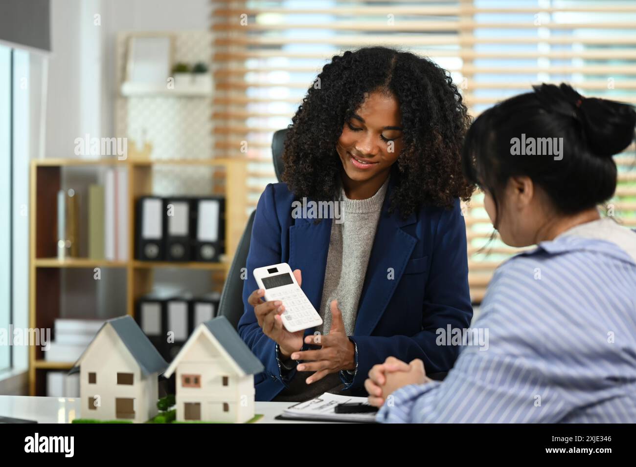 African American financial advisor holding calculator and showing about ...