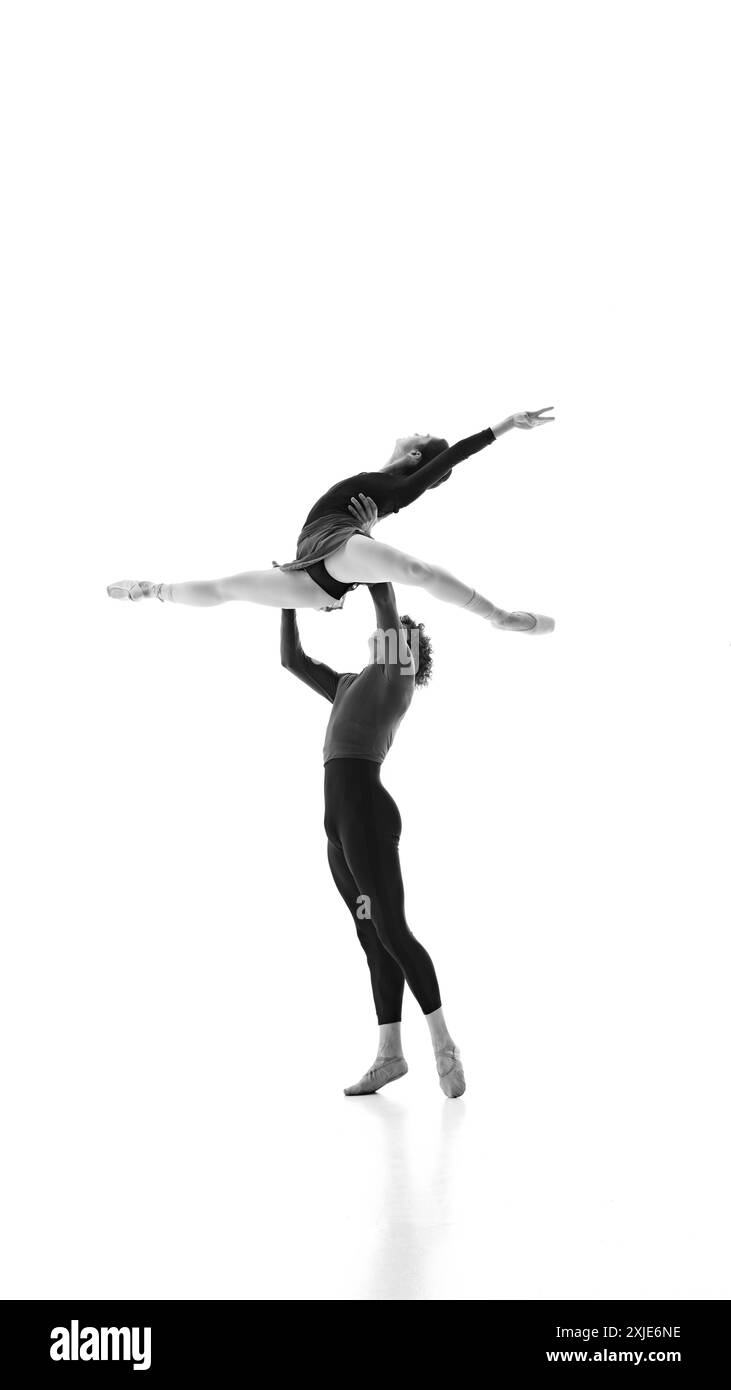 Dynamic duo in ballet training, focused on every move against white ...