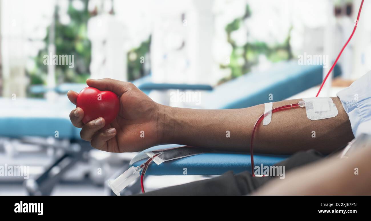 Close Up Shot Of Hand Of Male Blood Donor With an Attached Catheter. Black Man Holding Heart ...