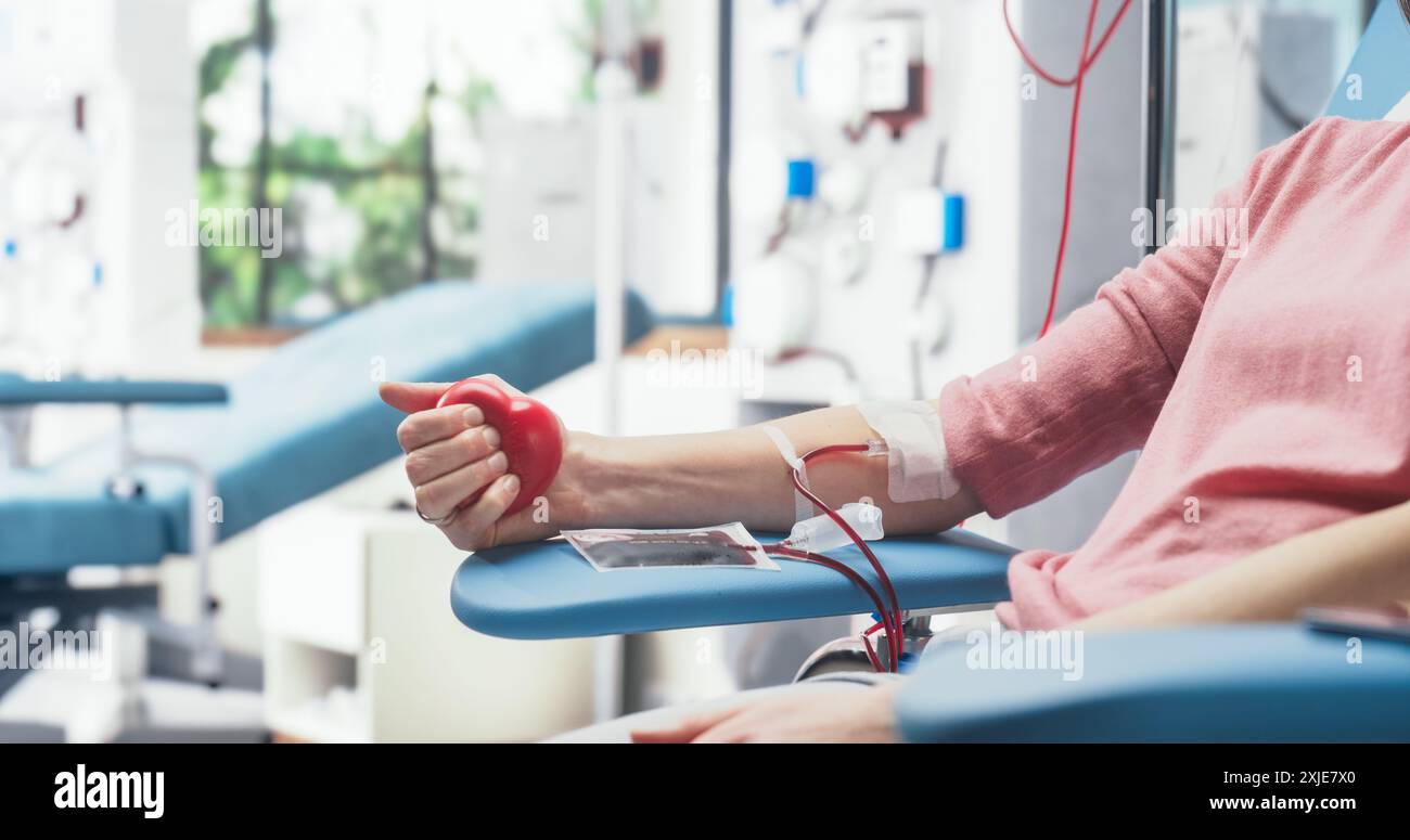 Close Up Shot Of Hand Of Female Blood Donor With an Attached Catheter. Caucasian Woman Squeezing ...