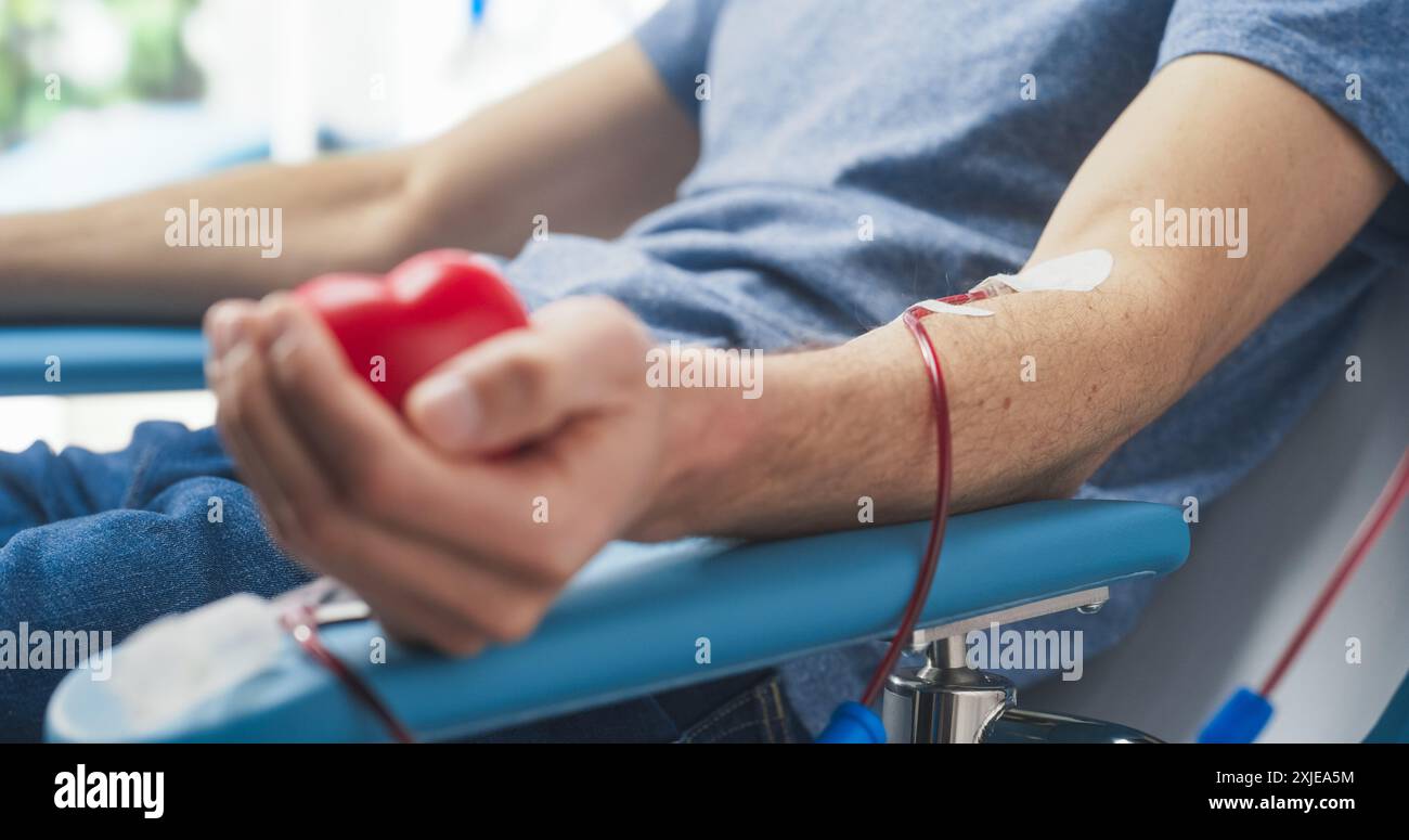 Close Up Shot Of Hand Of Male Blood Donor With an Attached Catheter ...