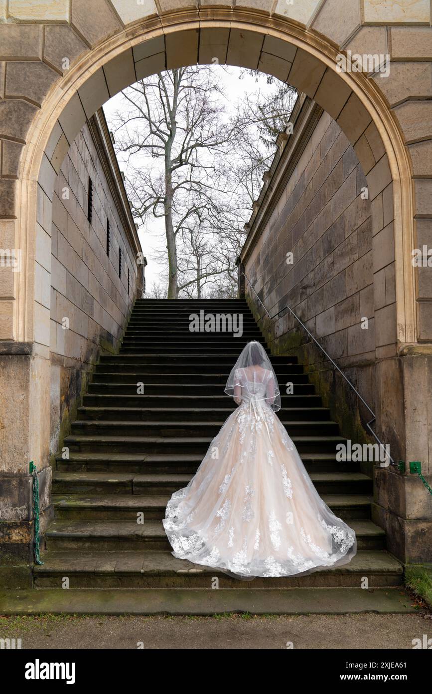 the bride walks along the stone steps of an ancient building, a palace ...