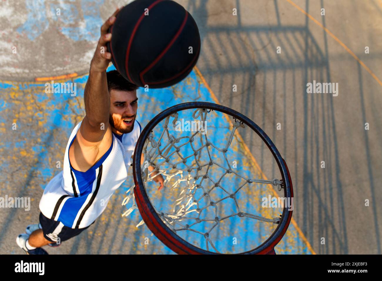 Top view of young man playing basketball outdoor. Slam dunk Stock Photo ...