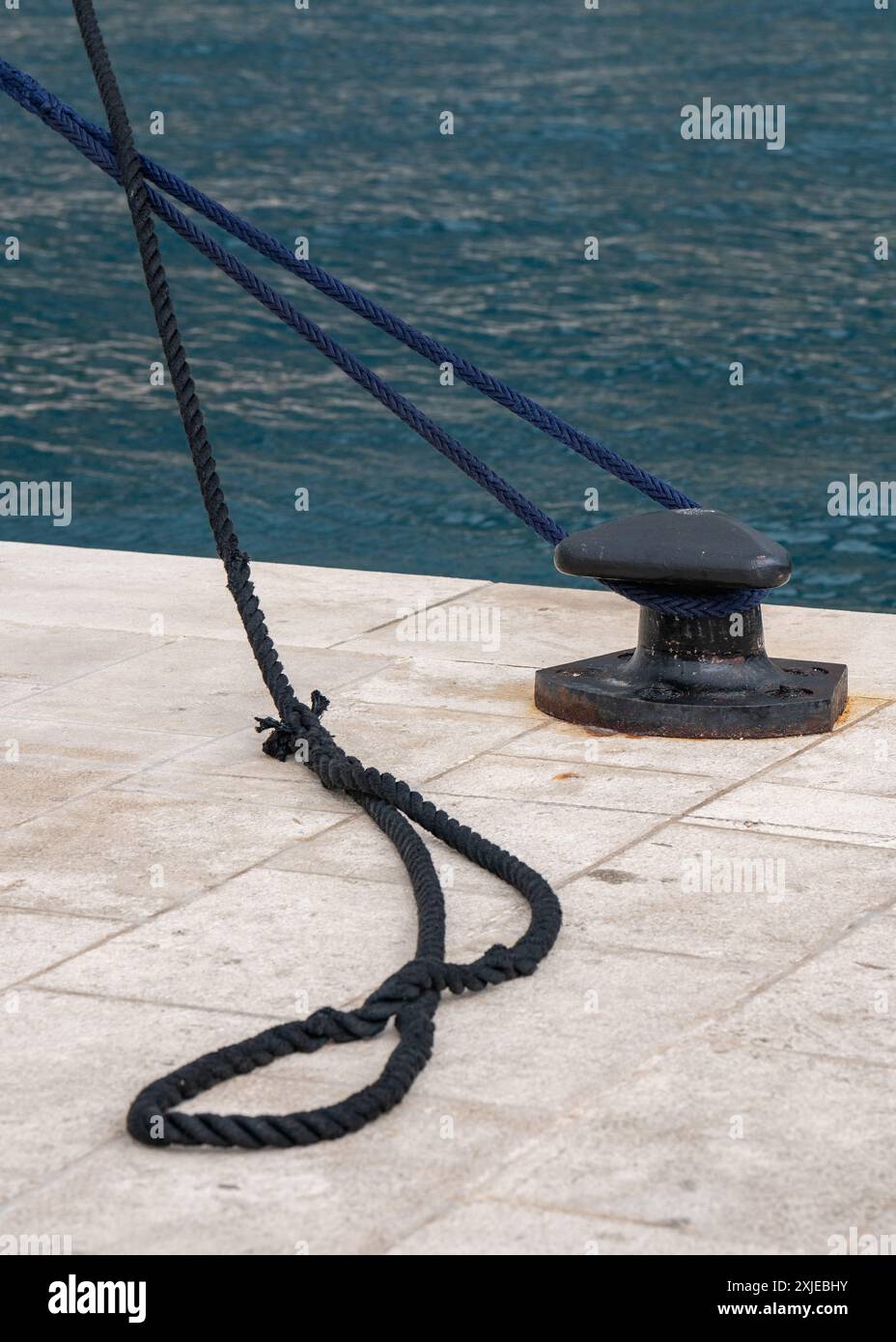 Mooring ropes on the pier. Close-up. Light berth with mooring blue and ...