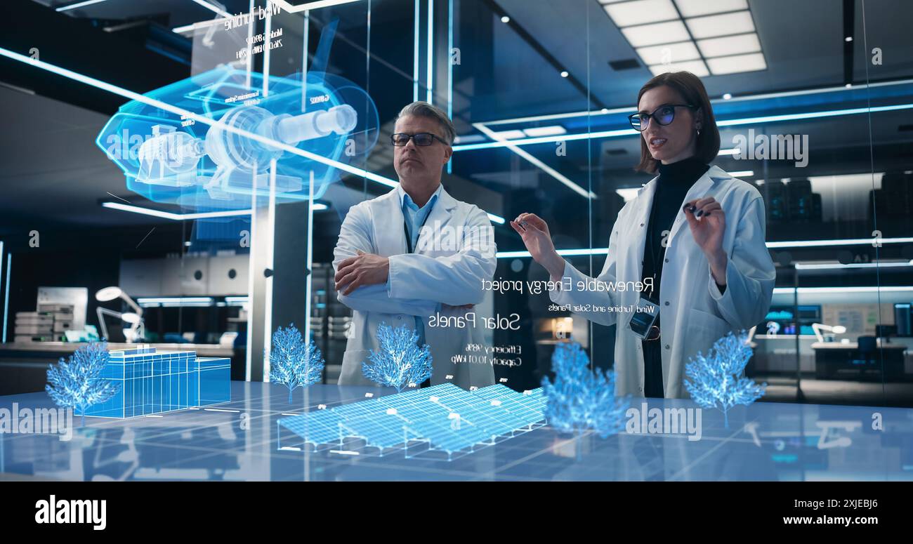 Male And Female Renewable Energy Engineers Using Futuristic Hologram of ...