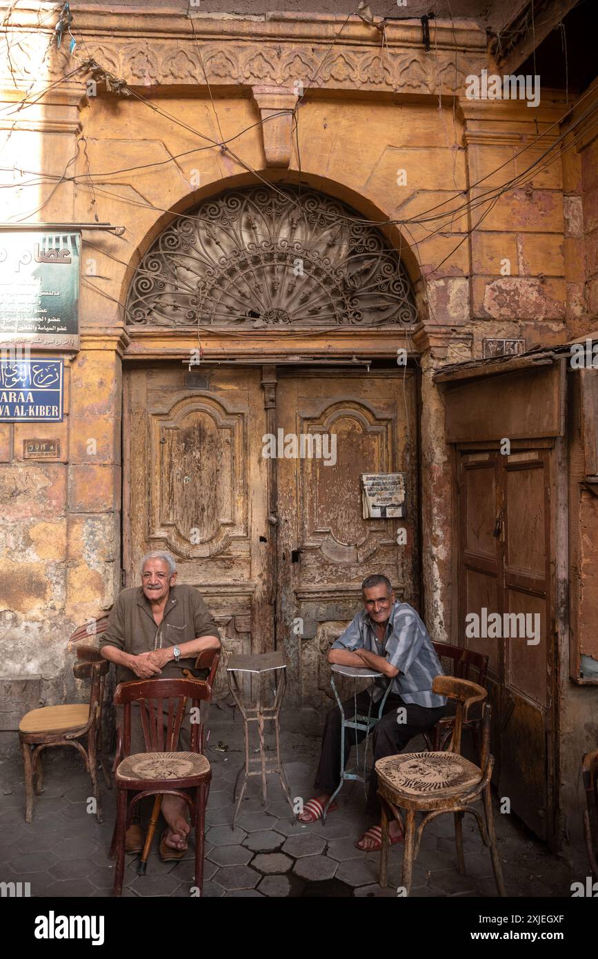 Cairo, Egypt. July 3rd 2024 Two old Egyptian men sit outside a café in ...