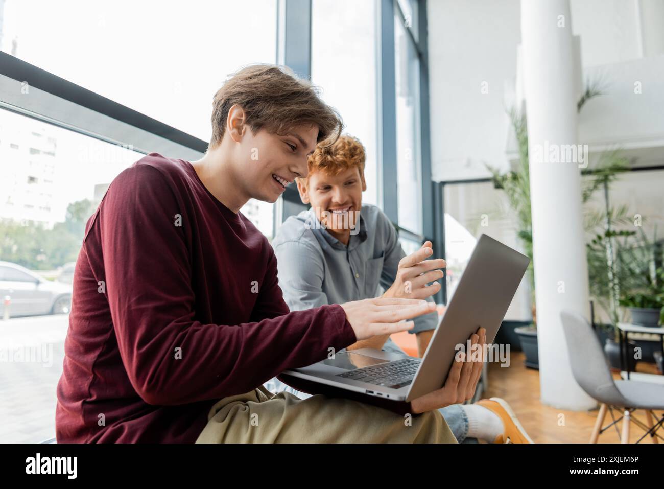Two male students engrossed in laptop screen, studying together Stock ...