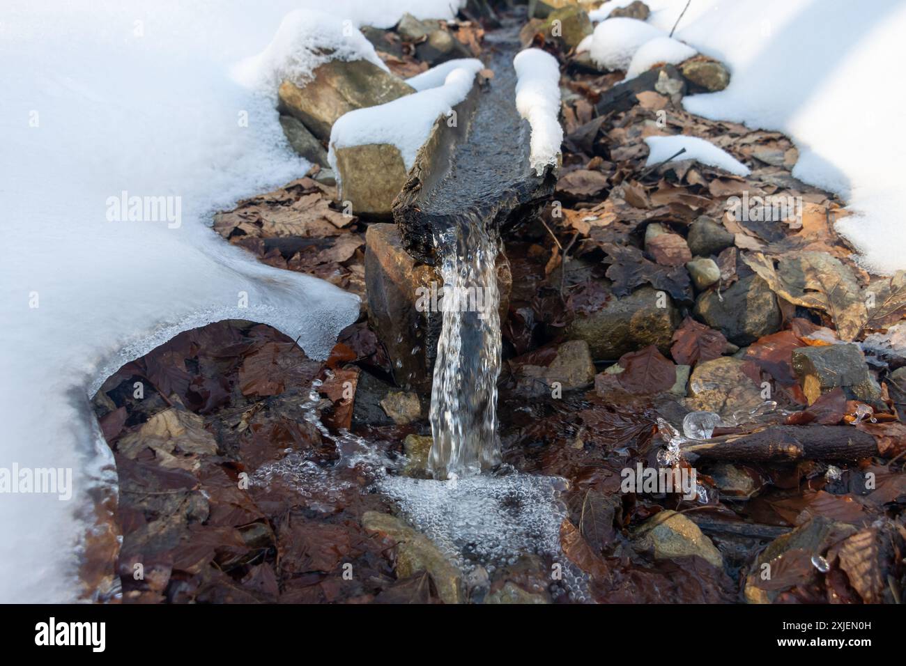 Water flows through a wooden trough in a snowy landscape Stock Photo ...
