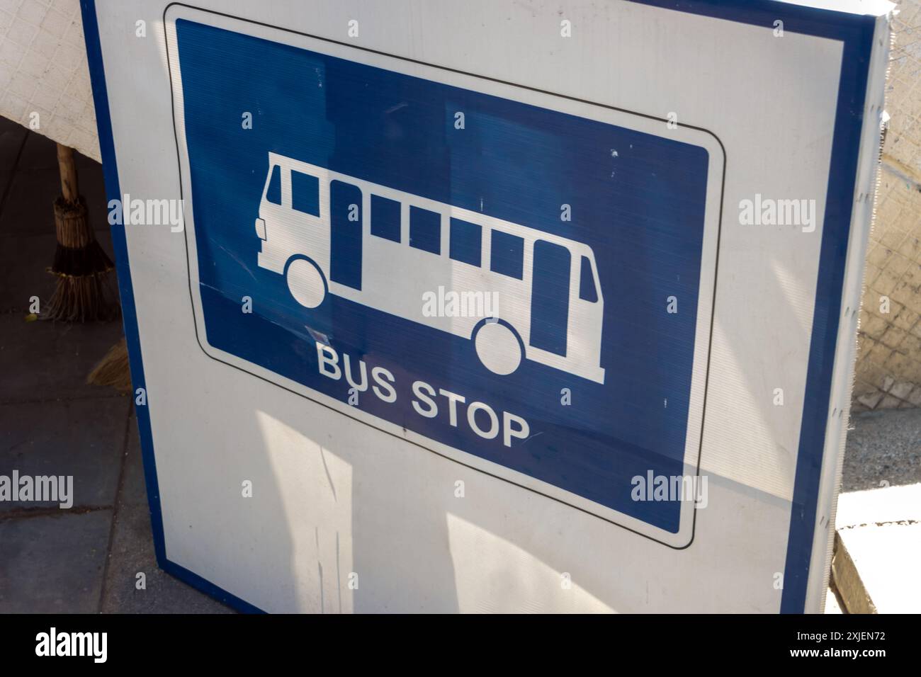 A sign on the sidewalk indicates a temporary city bus stop Stock Photo ...