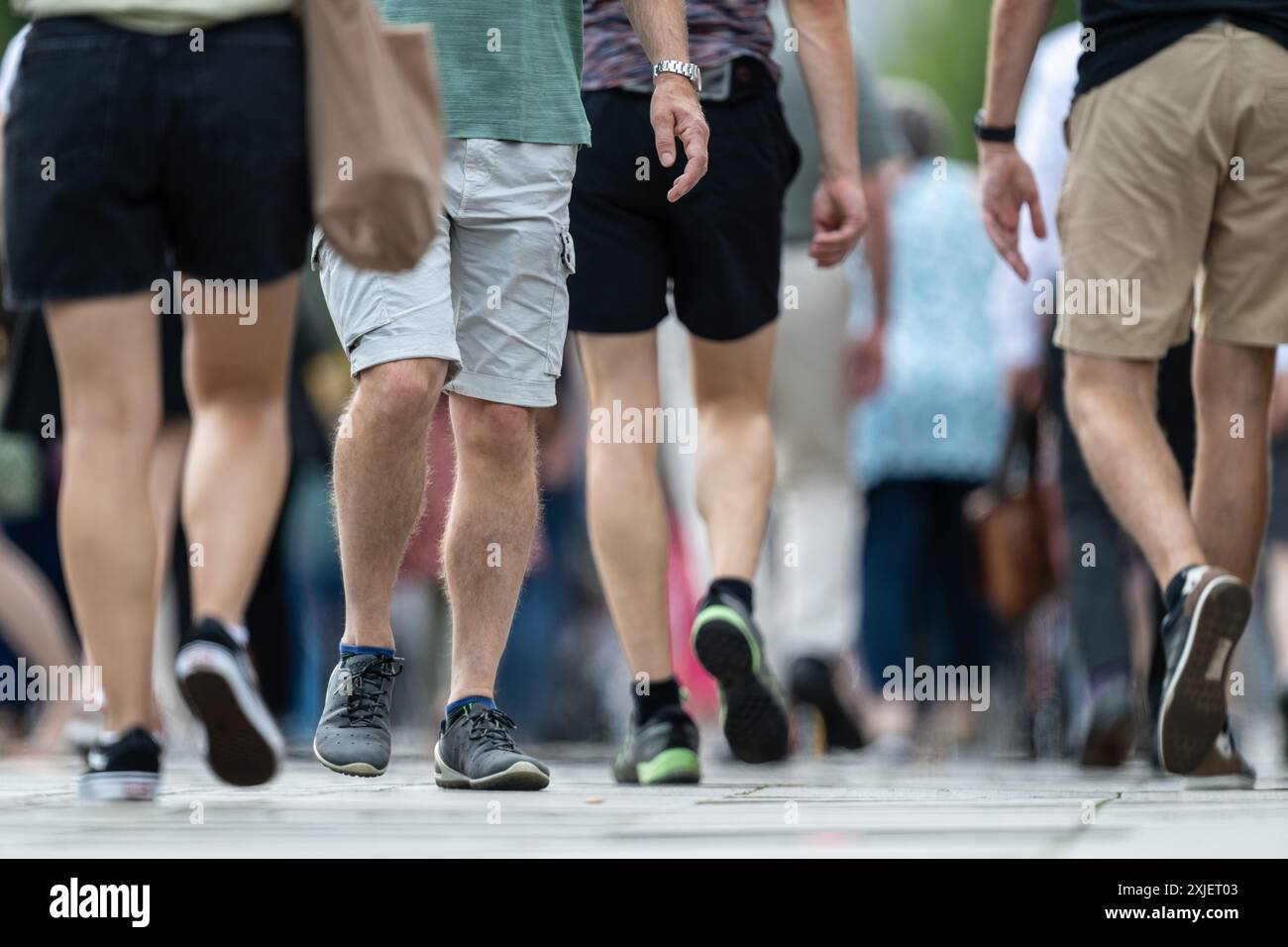 Stuttgart, Germany. 18th July, 2024. People in shorts walk along ...