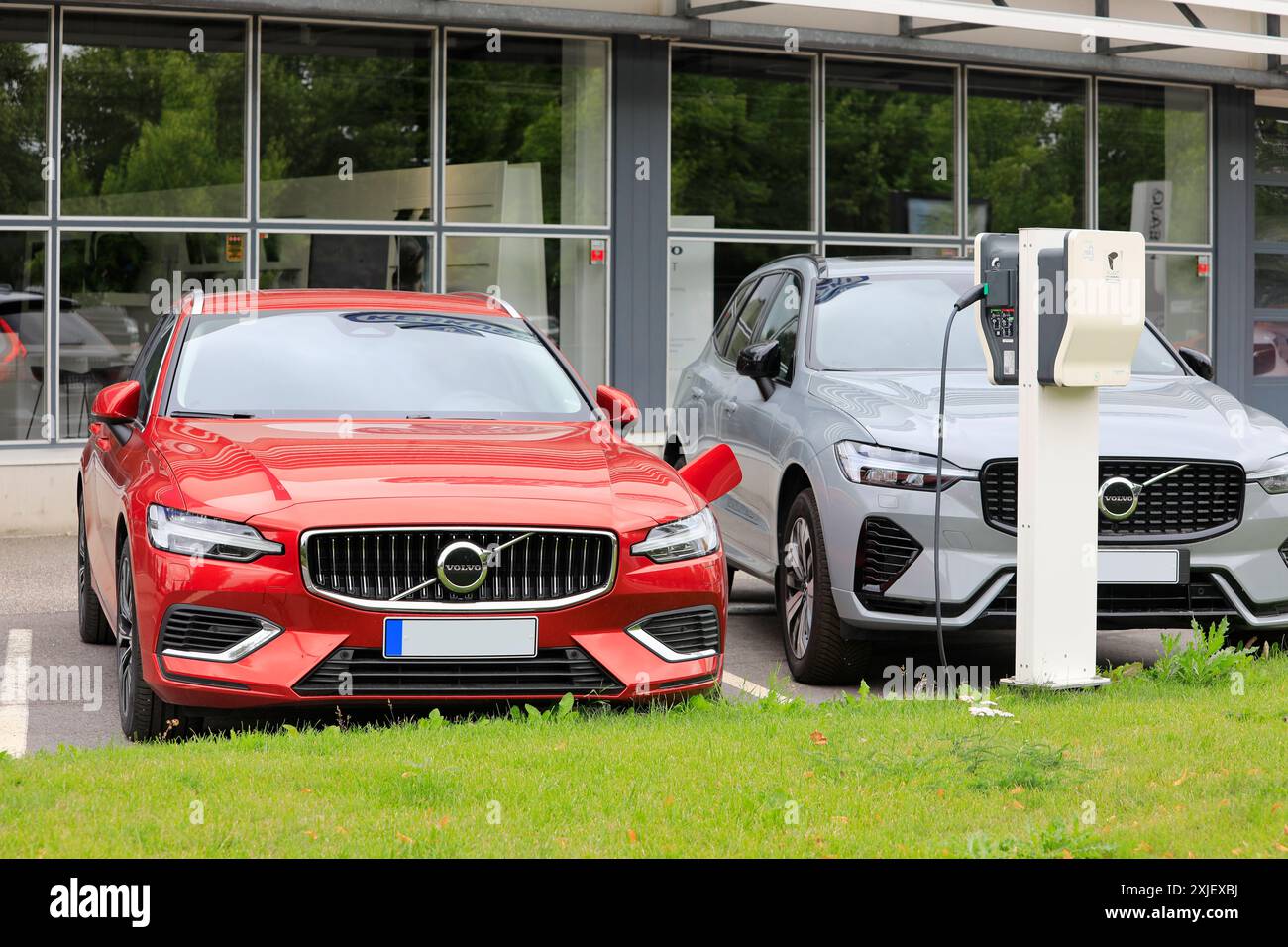 Red Volvo V60 (II) AWD 2024 hybrid electric car plugged in battery ...