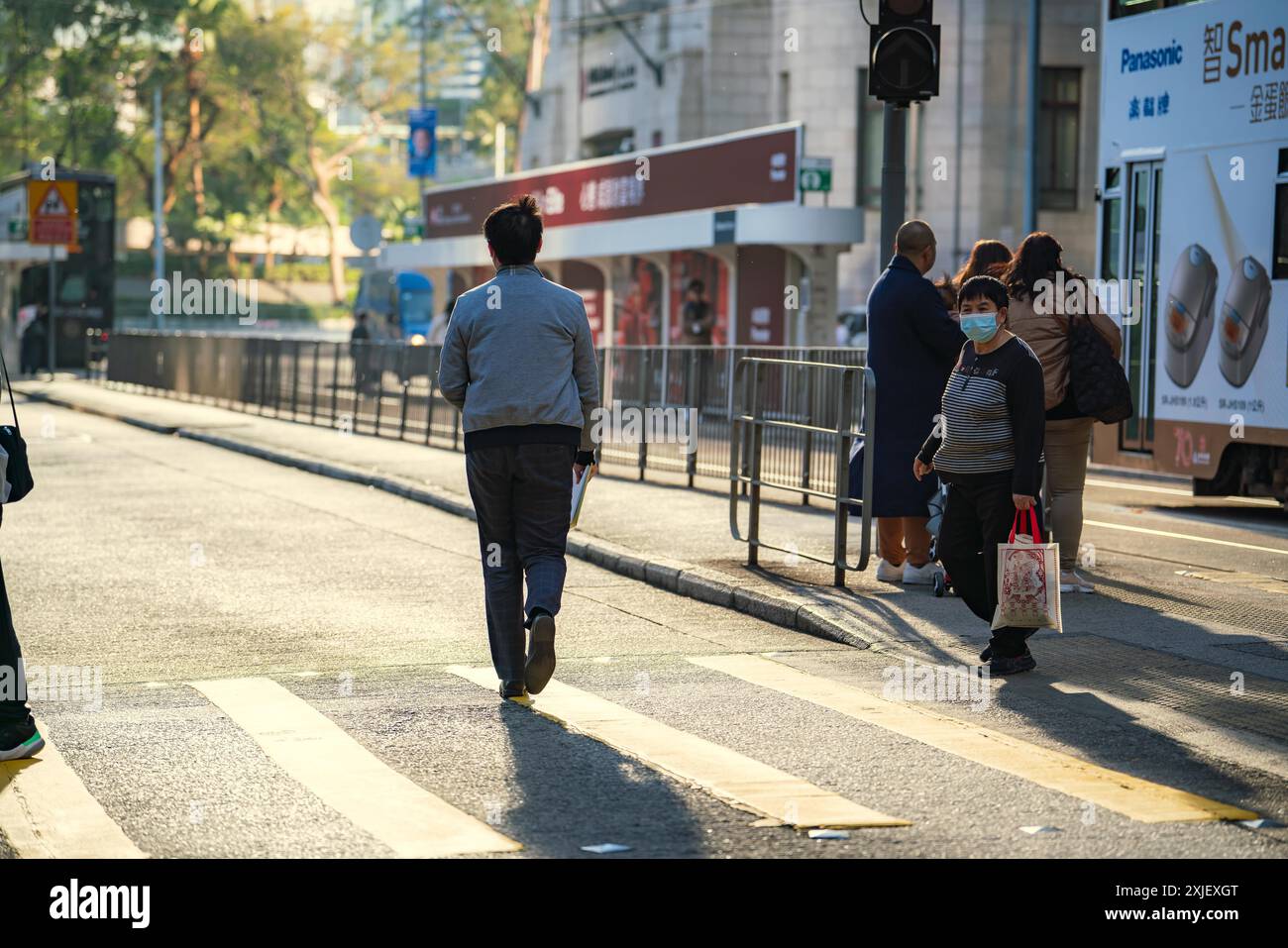 Hong Kong, China - January 03, 2024 : A man walks across a crosswalk in ...