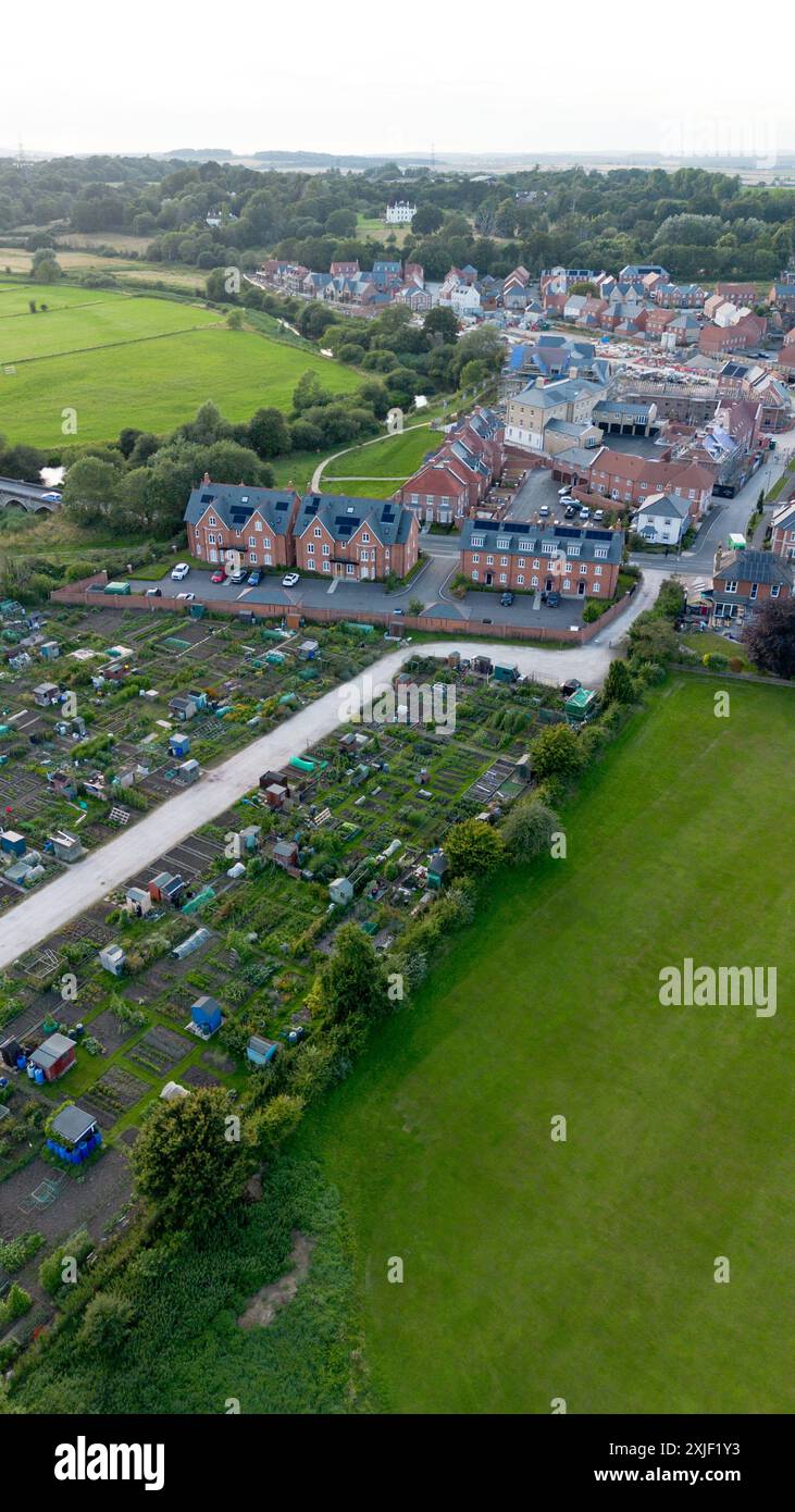 vertical crop aerial view of allotments, new build houses and distant ...