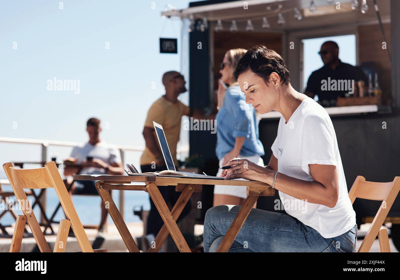 Typing, serious and woman with laptop, outdoor and restaurant in ...