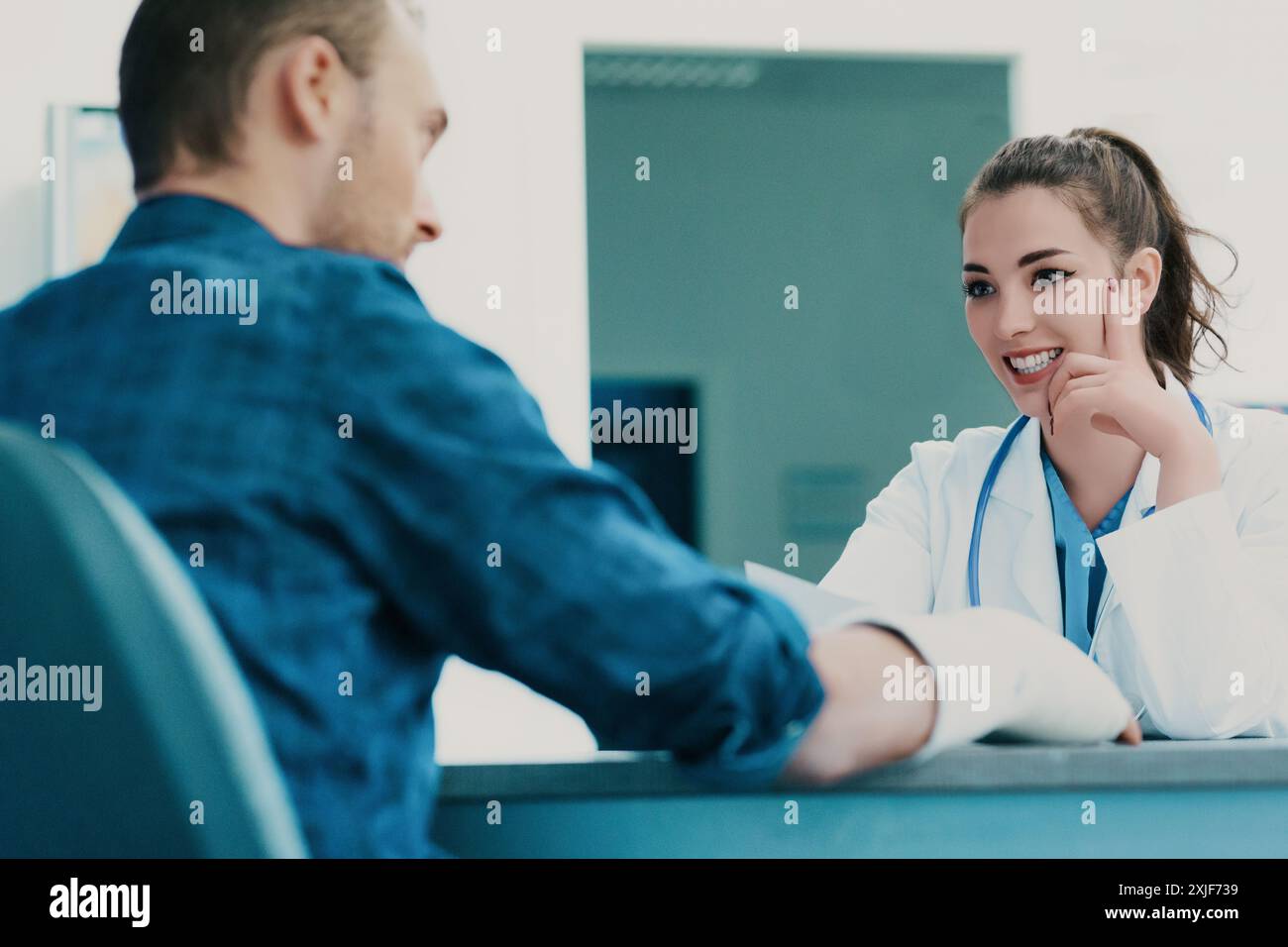 Female doctor smiling warmly, male patient with arm in cast, positive ...