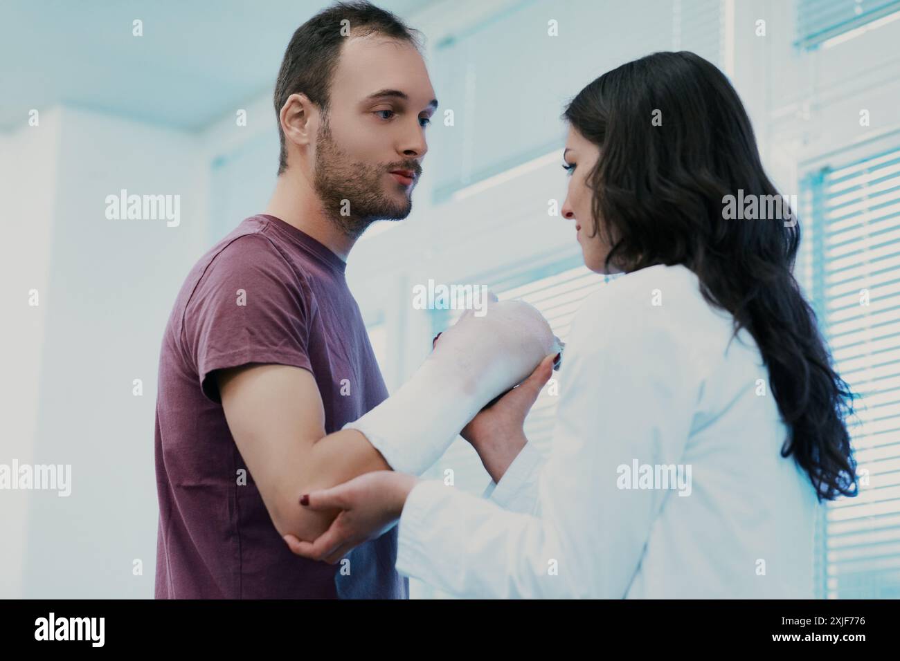 Skilled doctor examining broken arm in plaster cast, providing medical ...