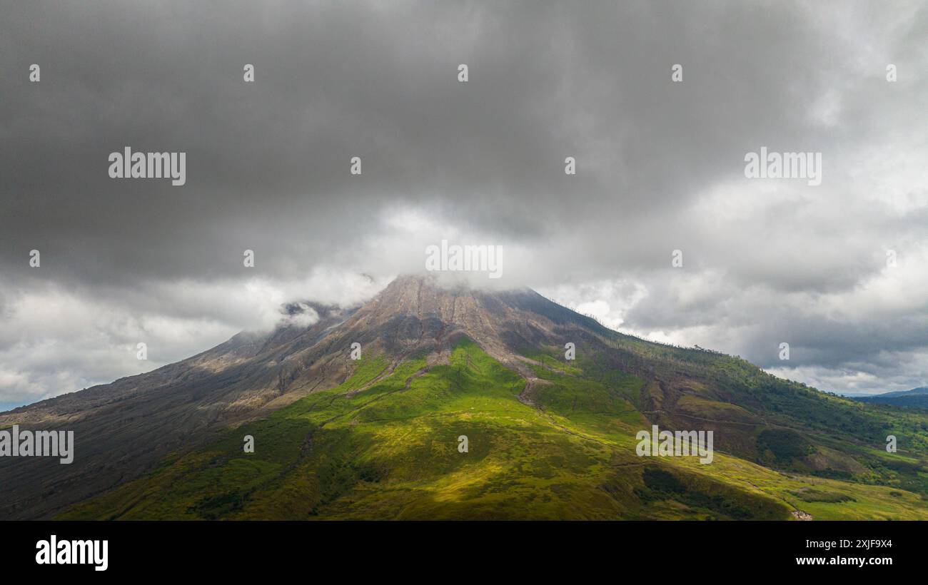 Aerial view of mount Sinabung active stratovolcano covered with clouds ...