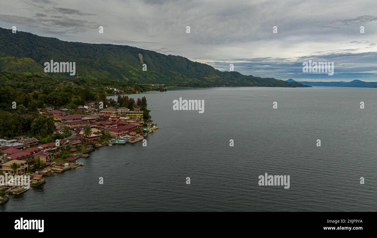 Aerial drone of Tourist spot Tuk Tuk on Lake Toba and the coast of ...