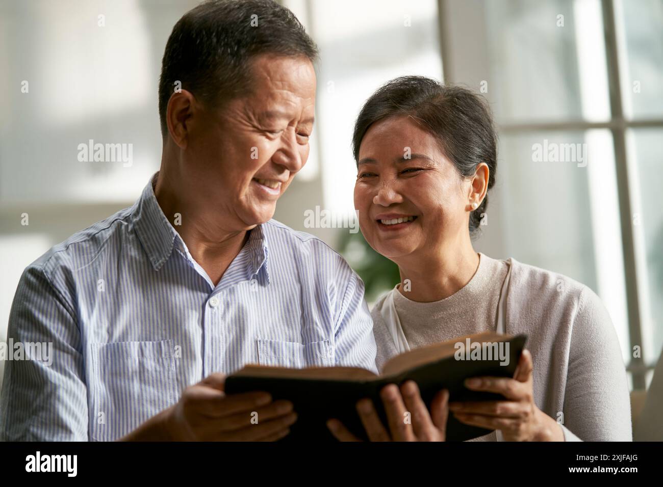happy senior asian couple sitting on family couch at home reading bible together Stock Photo - Alamy