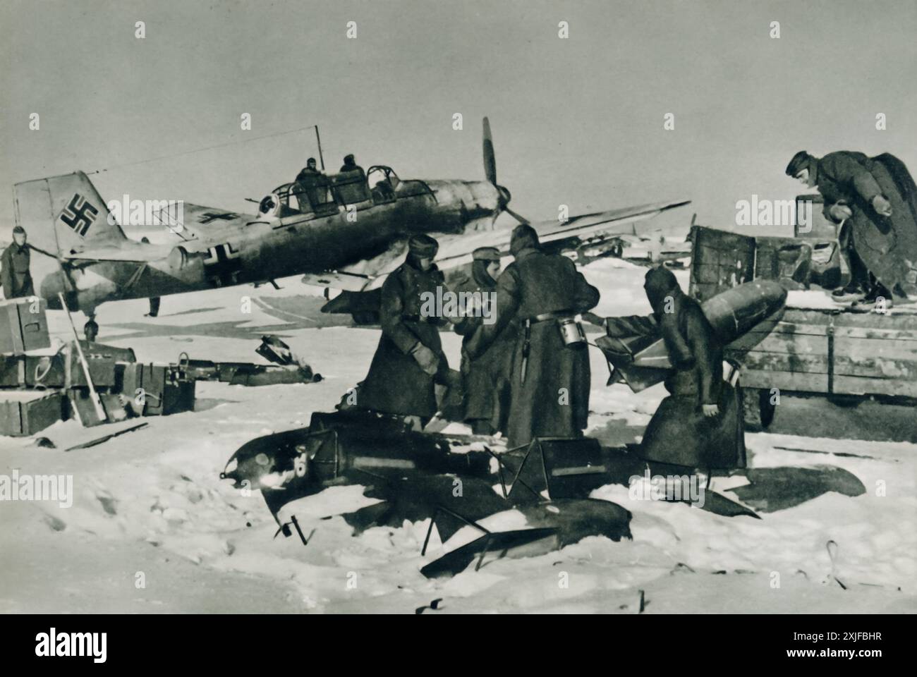 A photograph shows trucks delivering new bombs for the Junkers Ju 87 (Stuka) aircraft. Taken ...
