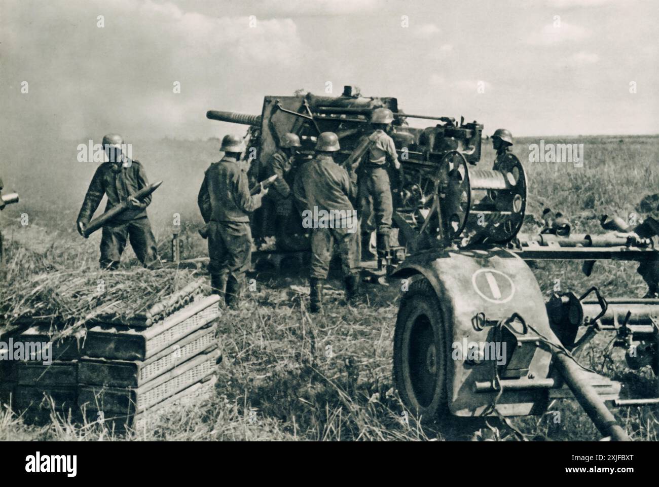A photograph shows a group of German soldiers operating an artillery ...