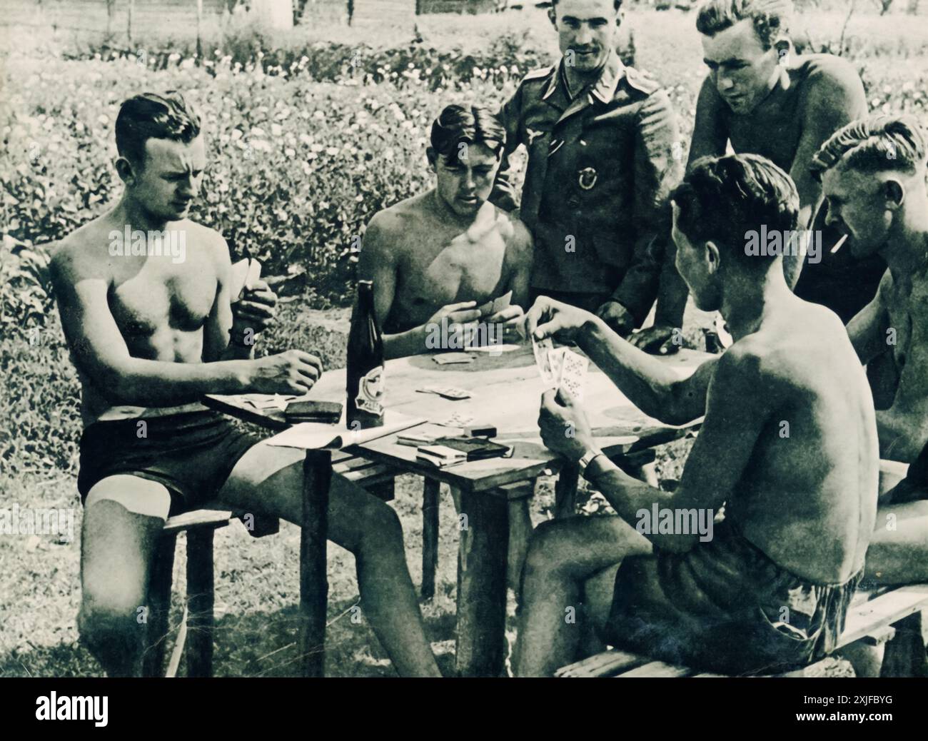 A color photograph captures German soldiers seated around a bench ...
