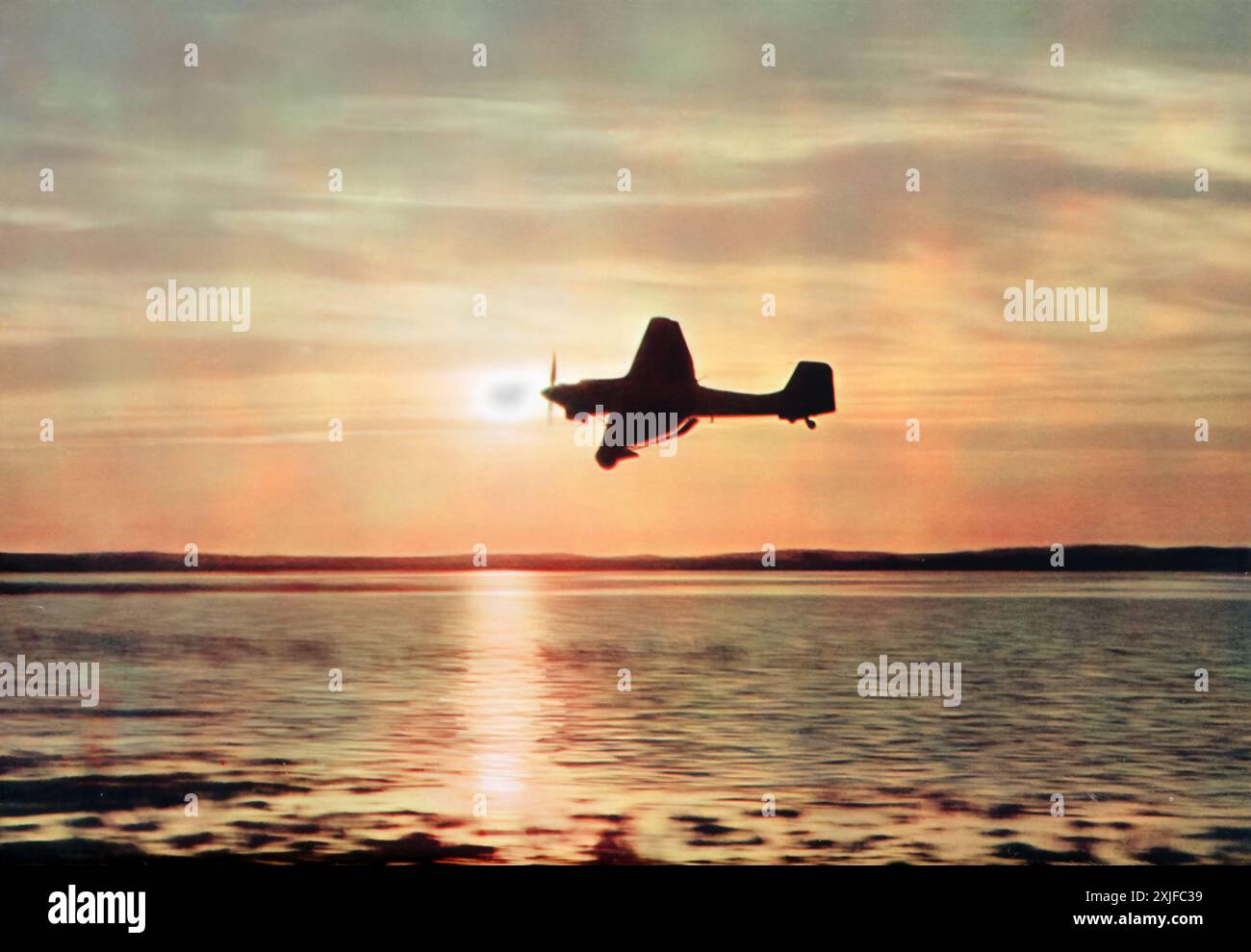 A photograph shows a Stuka (Ju 87) flying just above a lake against the ...