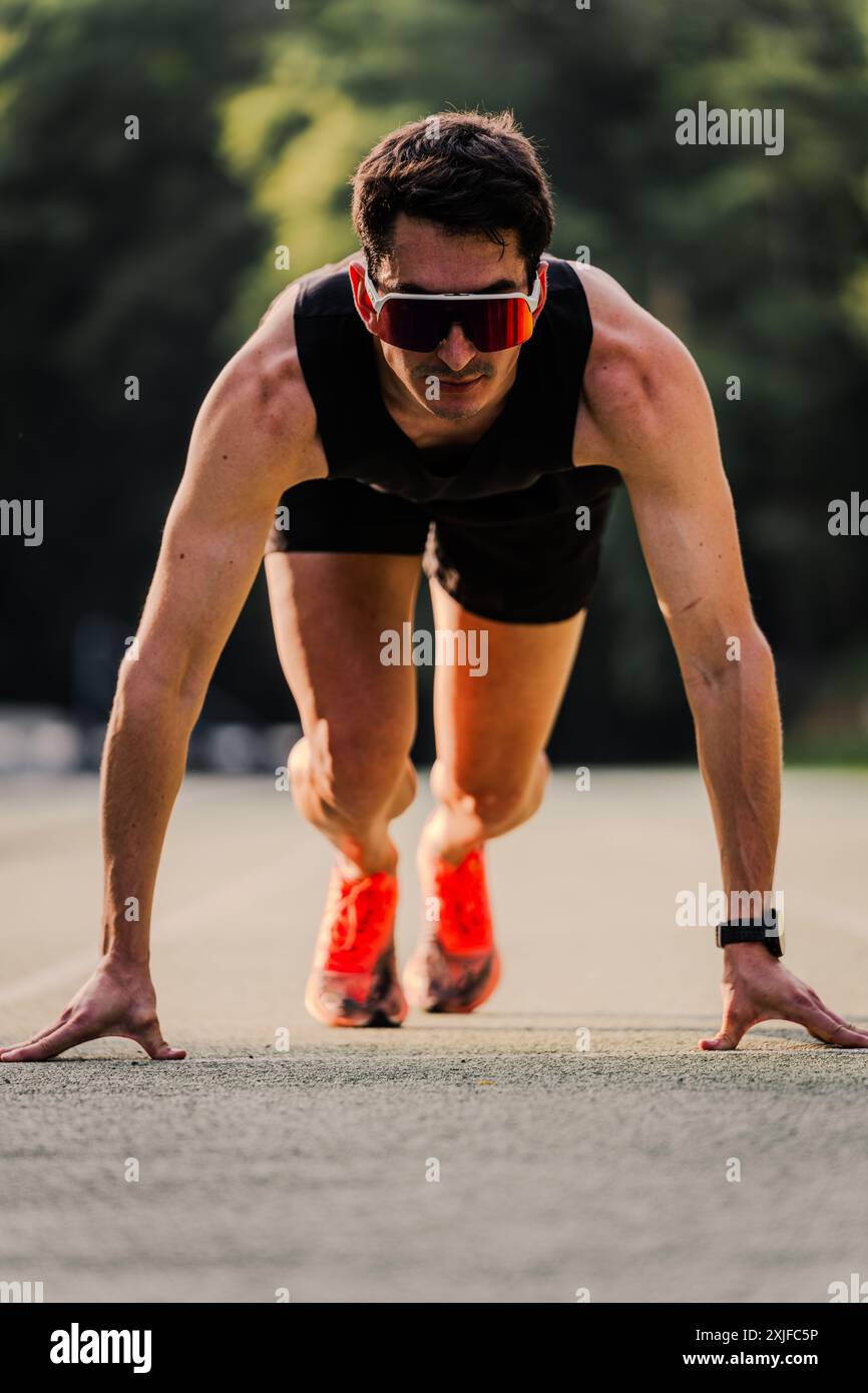 Expert athlete in starting position staring straight ahead with focused ...