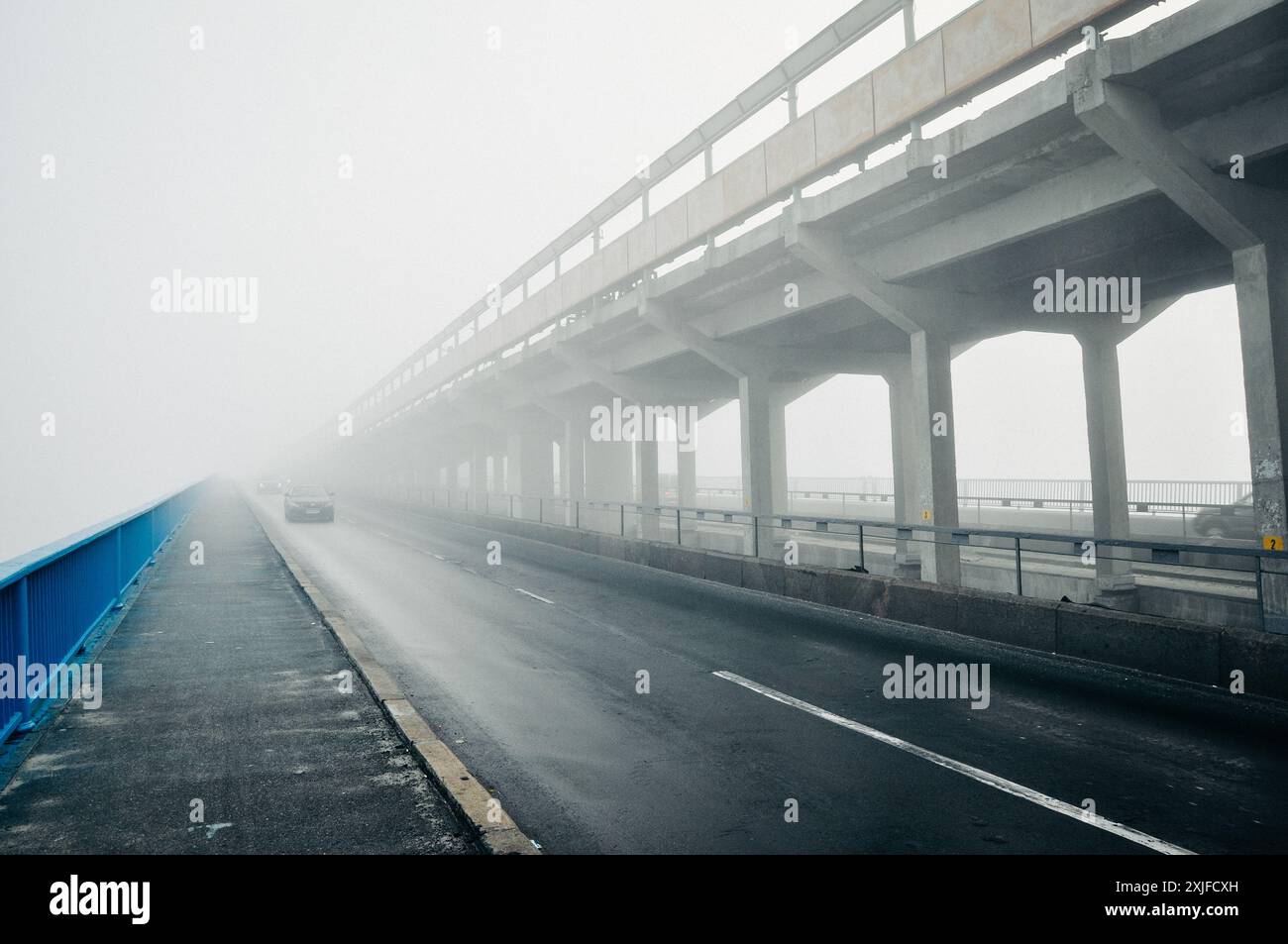 Cars driving on a bridge to nowhere. Concrete bridge covered in thick ...