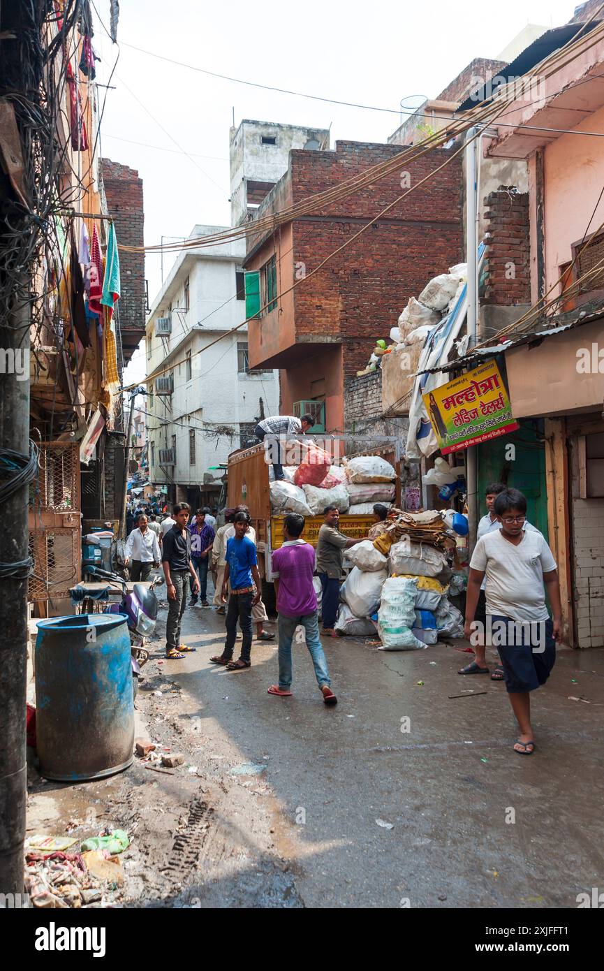 Busy street scene in India with people loading a truck and others ...