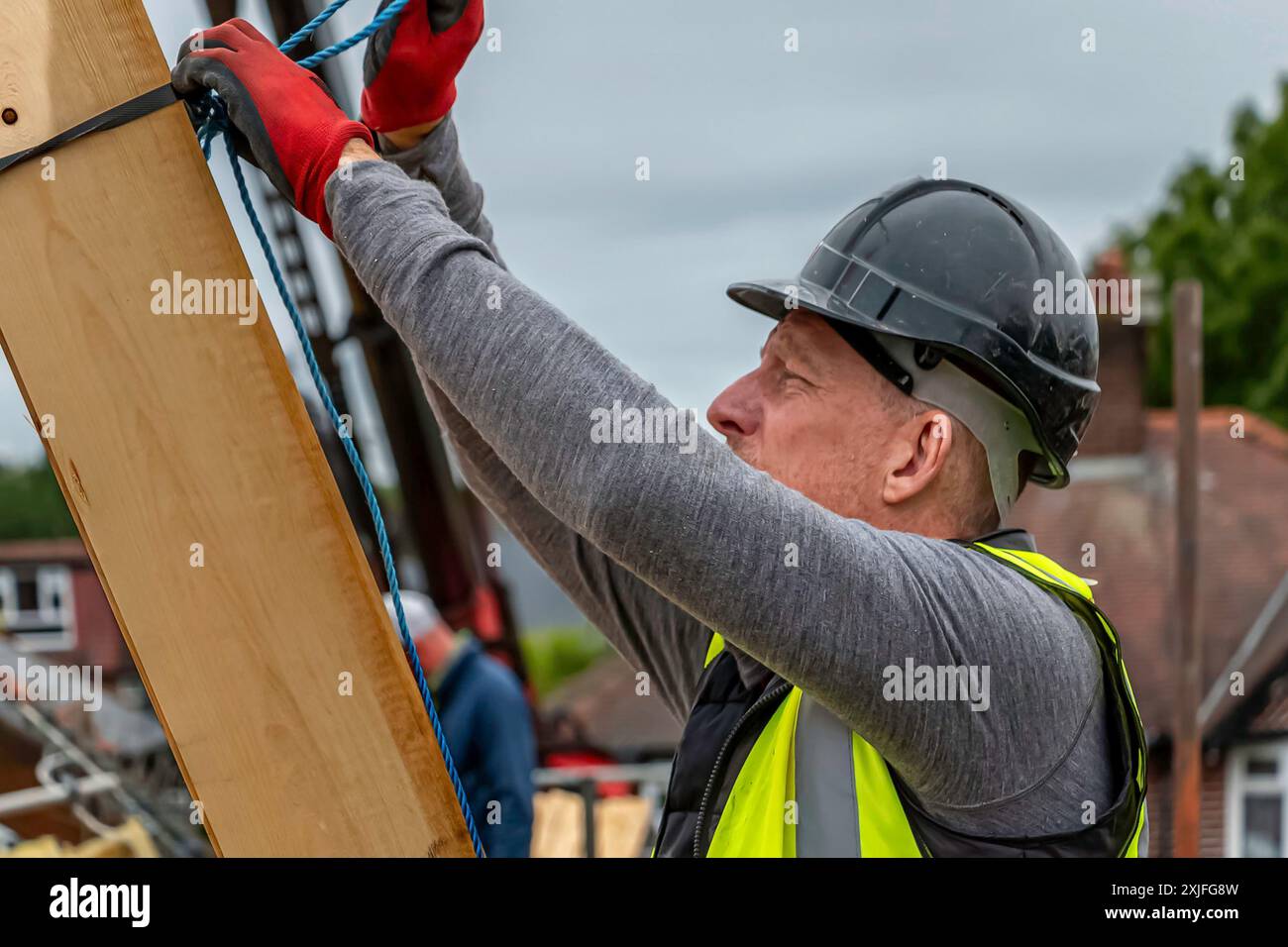 Construction workers working on assembling a new roof on a residential ...