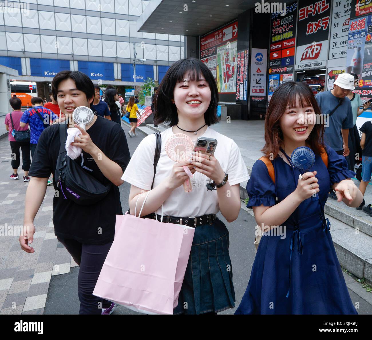 HEAT IN TOKYO GIRLS USING PORTABLE FANS Stock Photo - Alamy