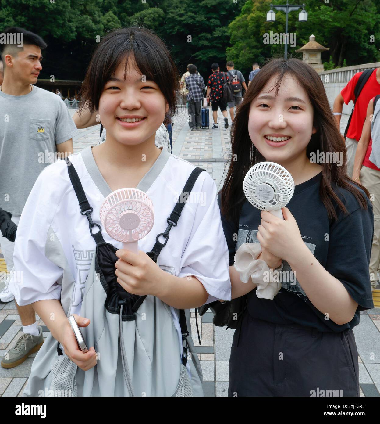 HEAT IN TOKYO GIRLS USING PORTABLE FANS Stock Photo - Alamy