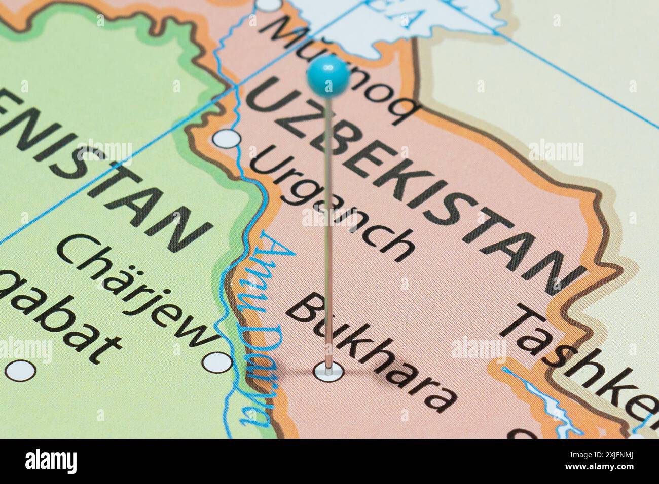 Close up to a Bukhara city with a light blue pin needle into Uzbekistan ...