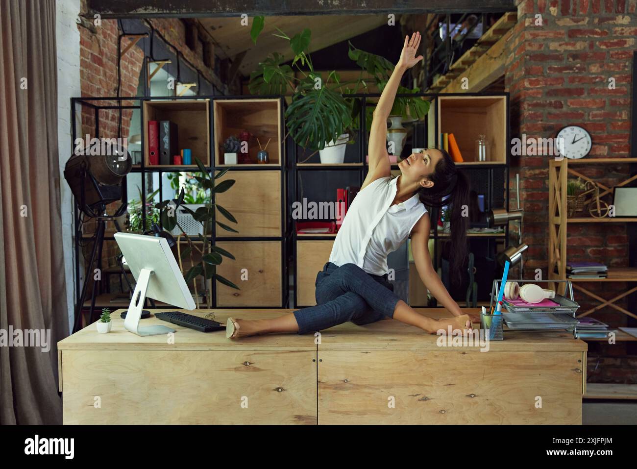 Positive woman, office worker sitting on desk and doing stretching ...