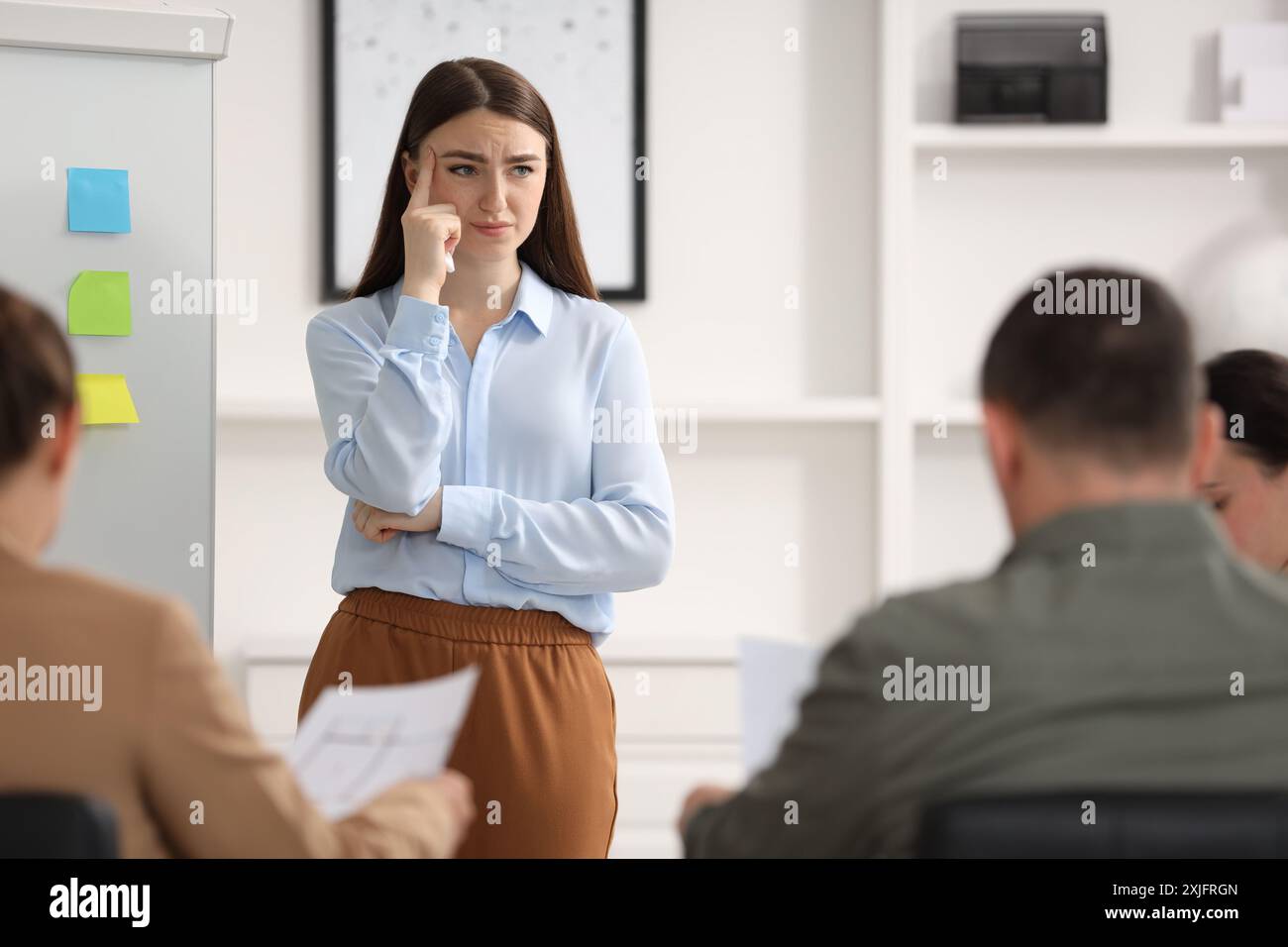 Woman feeling embarrassed during business meeting in office Stock Photo ...