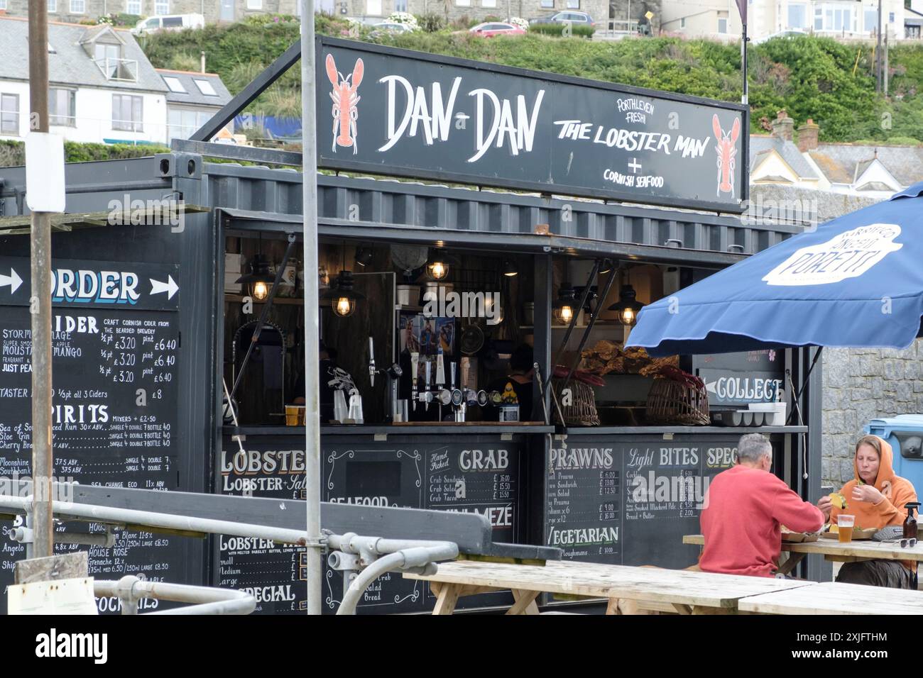 Two people eating outside at Dan-Dan the Lobster Man Portleven Harbour ...