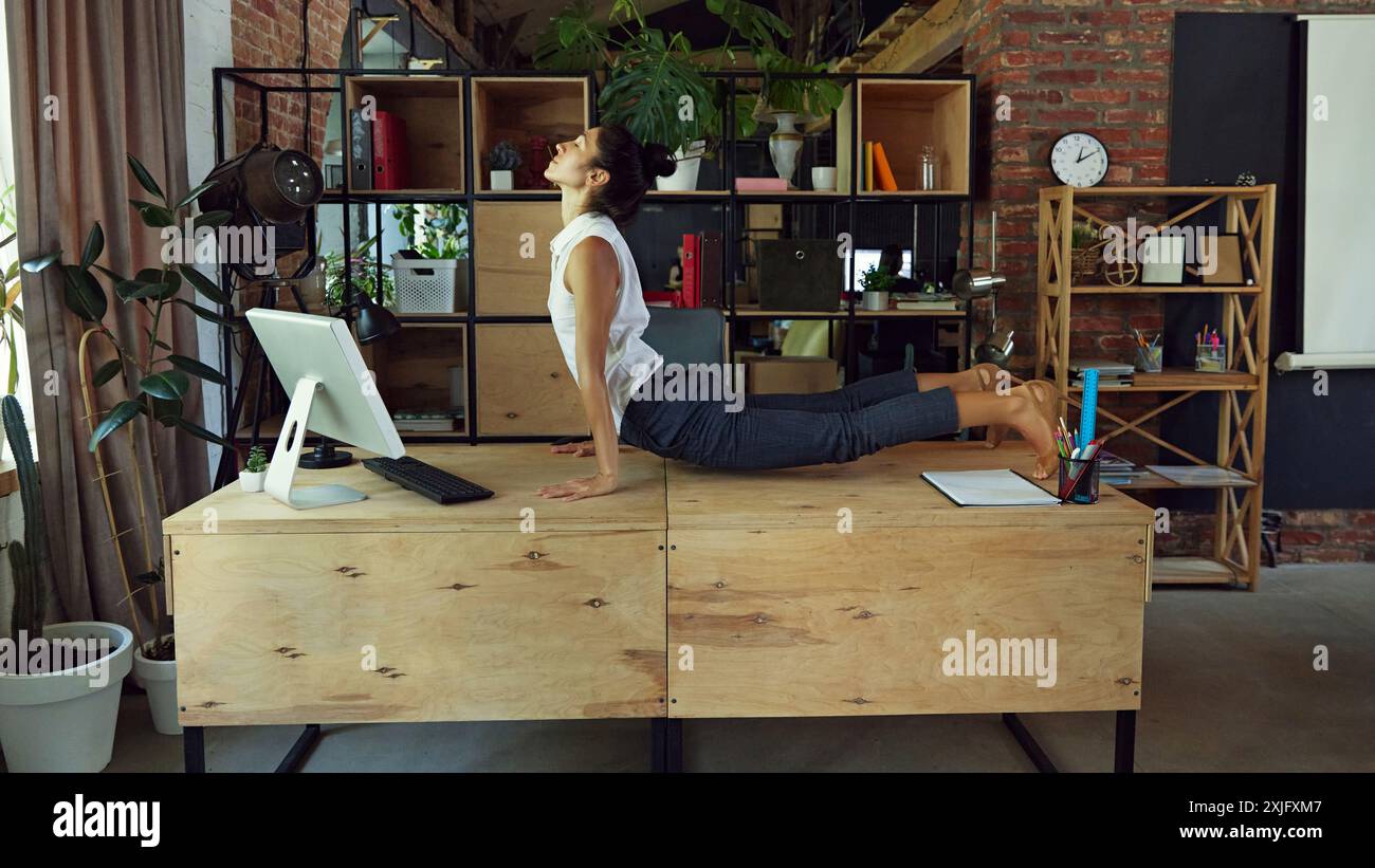 Woman, office employee on desk doing stretching activity, taking break ...