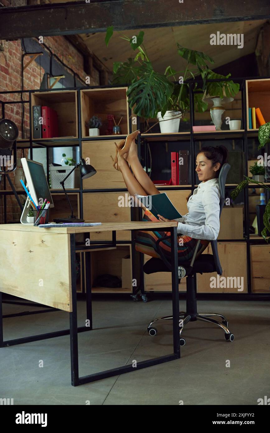 Woman, employee in modern office working with computer while doing ...