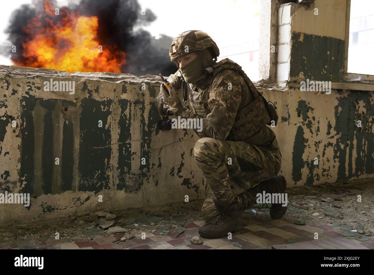Soldier using radio in destroyed building during military operation ...