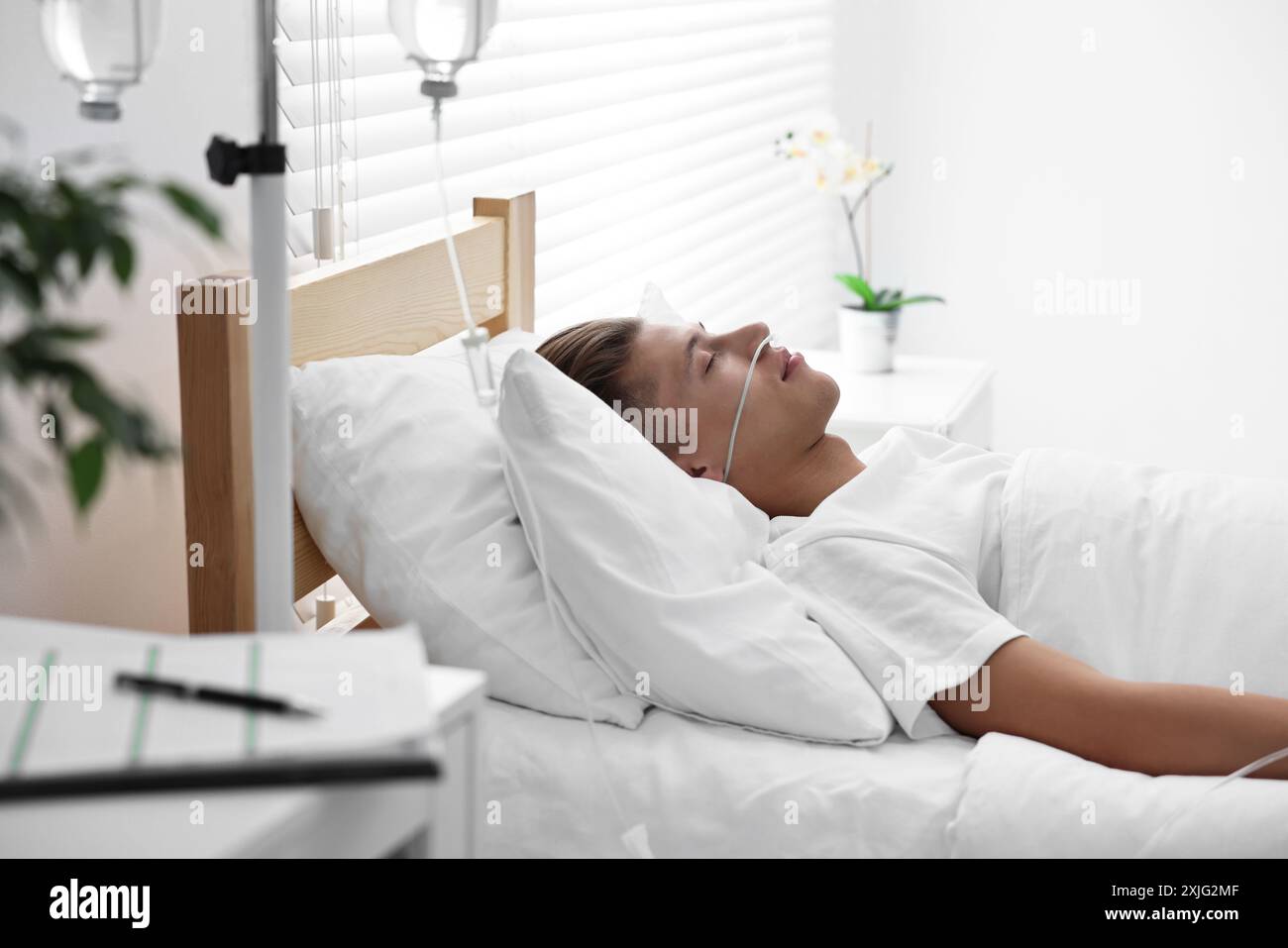 Coma patient. Young man sleeping in hospital bed Stock Photo - Alamy