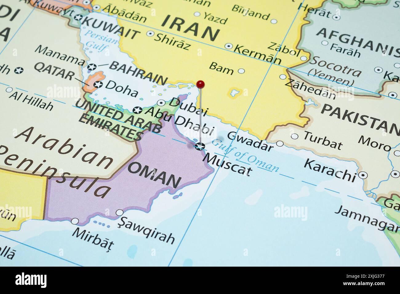 Close up to a Muscat city with a red pin needle into Oman country ...