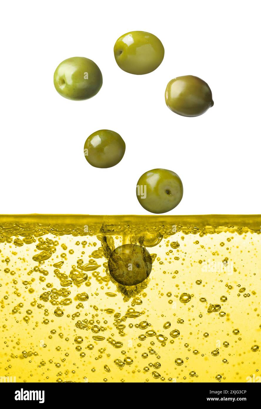 Green olives falling into cooking oil on white background Stock Photo ...