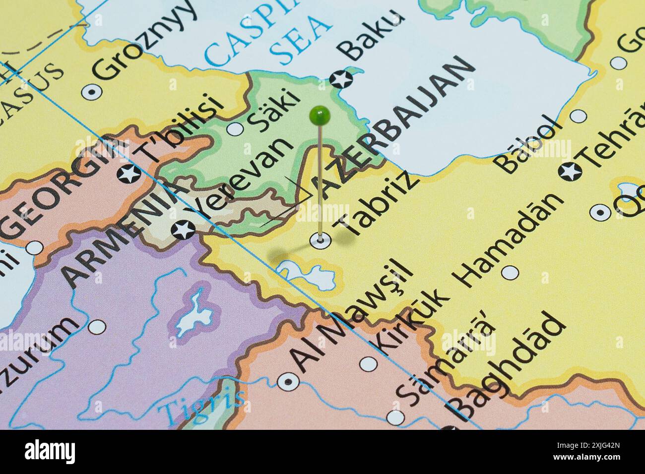 Close up to a Tabriz city with a green pin needle into Iran country ...