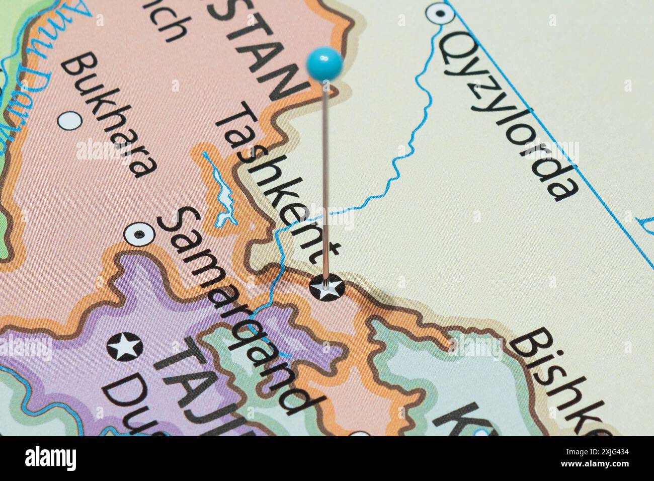 Close up to a Tashkent city with a light blue pin needle into ...