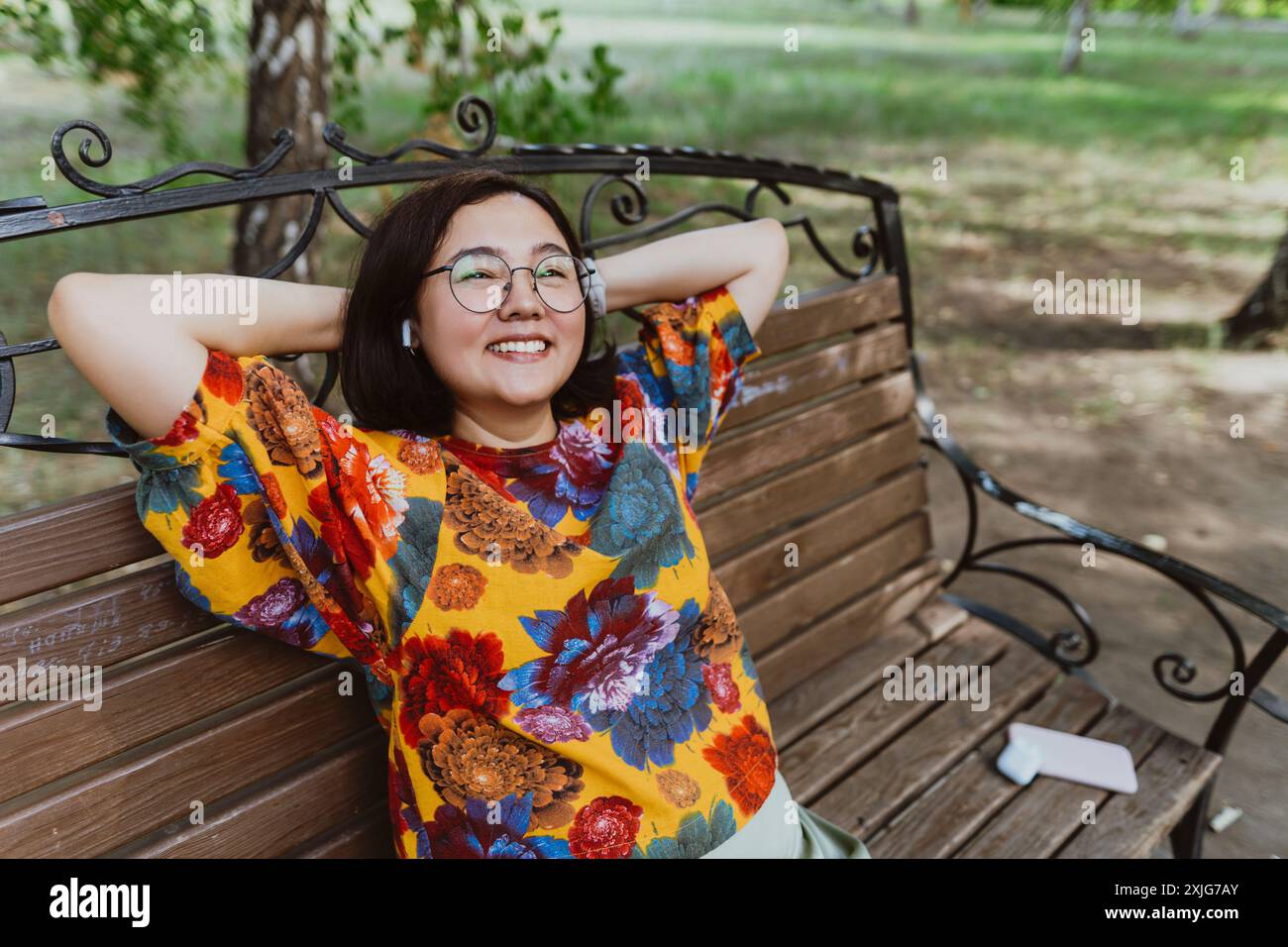 Casual leisure time captured as a smiling woman relaxes in nature with tunes Relaxed and happy ...