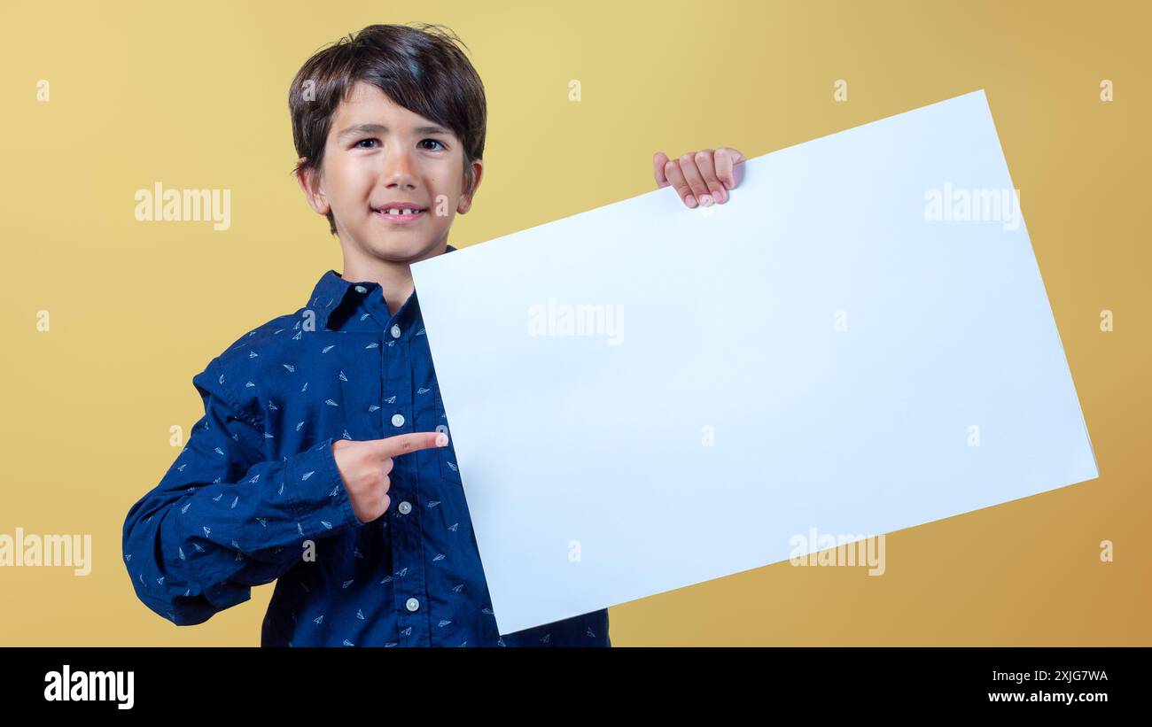 A kid holds up a white poster and points to it with his finger. Poster ...